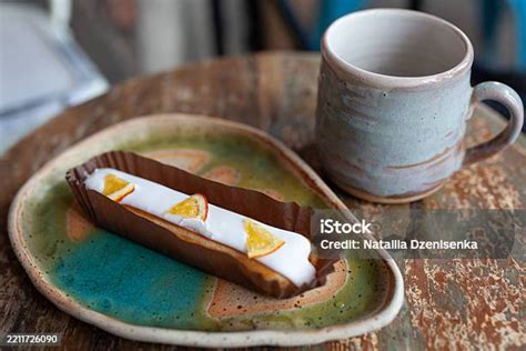 카페의 질감이있는 나무 테이블에 흰색 유약과 접시와 찻잔에 말린 오렌지 조각으로 장식 된 아름다운 Éclair 감귤류 과일에 대한 스톡 사진 및 기타 이미지 Istock