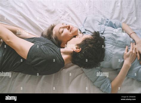 Man Kissing Woman Lying On Bed At Home Stock Photo Alamy