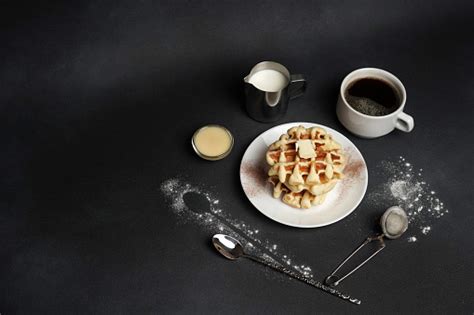 맛있는 와플 플레이트 카라멜 소스 커피 컵 우유 디저트 스푼 검은 콘크리트 배경에 여과기로 만든 수제 요리 복사 공간 0명에 대한 스톡 사진 및 기타 이미지 Istock