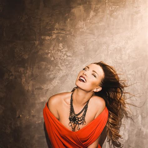 Retrato De Uma Menina Sexy Nova Bonita Em Um Vestido Vermelho E Em Uns Bordos Vermelhos Imagem