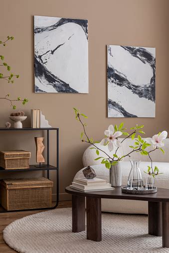 모형 포스터 프레임 나무 커피 테이블 부클 소파 원형 카펫 세련된 램프 조각품 목련이 있는 꽃병 개인 액세서리가 있는 봄 거실