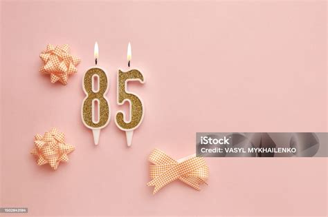 축제 장식이 있는 파스텔 핑크 배경에 숫자 85가 있는 양초 생일 축하 촛불 생일 기념일 중요한 날짜 휴일을 축하하는 개념입니다 복사 공간 기치 1에 대한 스톡 사진 및