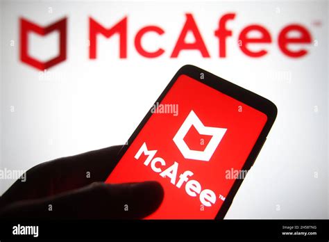 In This Photo Illustration A Mcafee Corp Logo Is Seen On A Smartphone And A Pc Screen Stock