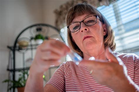 현대 중산층 집에서 포도당 측정기로 혈당 수치를 확인하는 성숙한 여성 글라우코미터에 대한 스톡 사진 및 기타 이미지 글라우코미터 여자 개성 개념 Istock