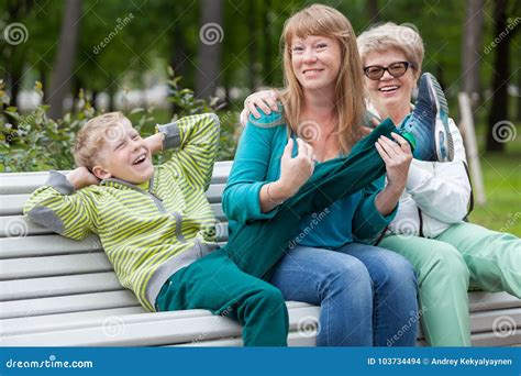 Gli Adulti Generano Il Giovane Figlio E Nonna Senior Divertendosi Sul Banco Nel Parco Dell