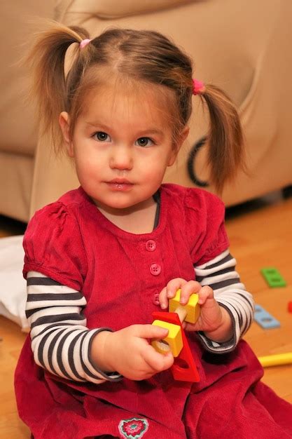 Premium Photo Portrait Of Cute Girl Playing With Toy At Home