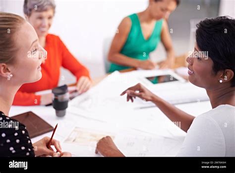 Discussing The Plans A Group Of Female Architects Working Together On A Project At A Conference