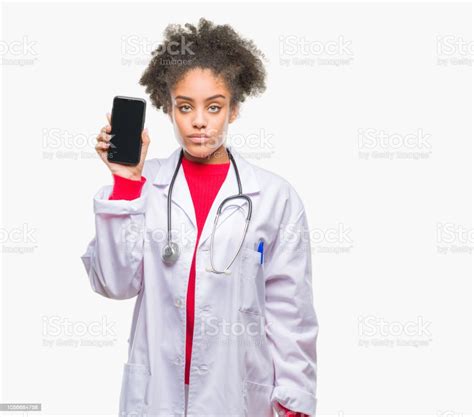 젊은 아프리카 미국 의사 여자 스마트 얼굴 심각한 생각에 자신감이 식으로 고립 된 배경 위에 스마트폰을 사용 하 여 감정에 대한 스톡 사진 및 기타 이미지 Istock