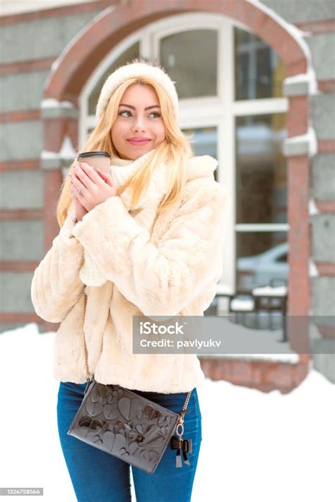 흰색 모피 코트를 입고 커피 한 잔을 들고 세련된 금발 여자의 거리 초상화 20 24세에 대한 스톡 사진 및 기타 이미지 20 24세 거리 걷기 Istock