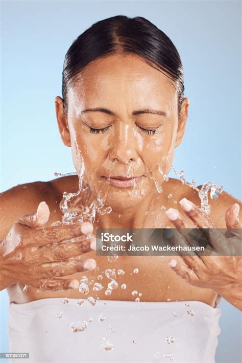 늙은 여자 얼굴과 물이 튀는 청소 아름다움 파란색 배경에 노화 방지로 지속 가능한 스킨케어 손 건강한 피부 친환경 피부과 천연 화장품 스튜디오의 여성 세안에 대한 스톡 사진
