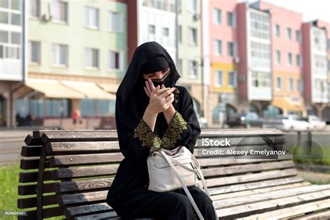한 무슬림 여성이 공원의 벤치에서 쉬고 거울을 보며 자신을 정리하고 있습니다 거리에 대한 스톡 사진 및 기타 이미지 거리 걷기 검은색 Istock