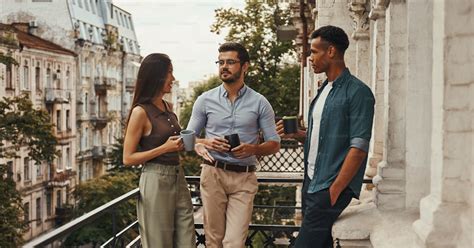 대화 캐주얼 복장을 입은 젊은 쾌활한 동료들은 발코니에 서서 컵을 들고 서로 이야기합니다 동료들이 쉬고 있다 커피 브레이크 사진 Unsplash의 커피 음료 이미지