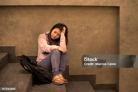 젊은 슬 프 고 우울 아시아 중국 학생 여자 또는 야외에서 압도 하 고 절망적 인 기분이 불안 거리 계단에 앉아 왕 따 십 대