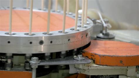 A Machine Processes Wooden Dowels Arranging Them Vertically In A