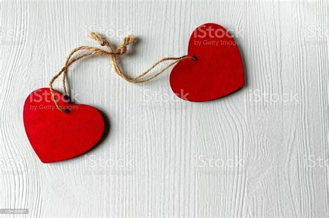두 개의 빨간 하트가 흰색 나무 테이블에 서로 닿는 매듭이 있었고 왼쪽 아래 모서리에 복사 공간이 있습니다 목재 재료에 대한 스톡 사진 및 기타 이미지 Istock