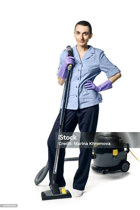 하얀 배경에 고립 된 진공 청소기를 준비하고 미소짓고 진공 청소기를 준비하는 하녀 의상을 입은 젊은 아름다운 여성 가사 집안일에