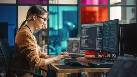 Young Caucasian Woman Programming On Desktop Computer With Two Monitors Setup In Spacious Office