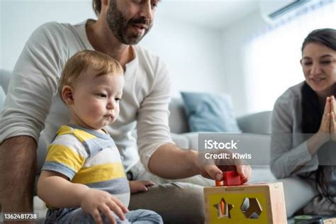 백인 행복한 사랑하는 부모는 거실에서 아기 유아와 놀고 있습니다 매력적인 부부 어머니와 아버지는 집에서 어린 어린 유아 아들과