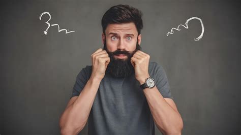 Premium Photo Nervous Bearded Male Bites Finger Nails Holds Wrist Watch Worries As Being Late