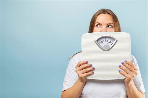 갈색 머리 여자 흰색 비늘을 들고 파란색 배경에 텍스트에 대 한 빈 공간을 향해 찾고 저울에 대한 스톡 사진 및 기타 이미지 저울 무서움 무거운 Istock