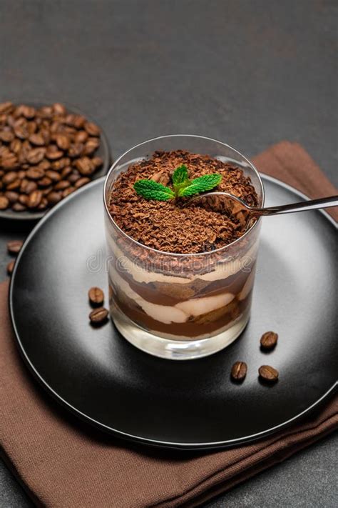 Classic Tiramisu Dessert In A Glass Cup And Pieces Of Chocolate On Dark
