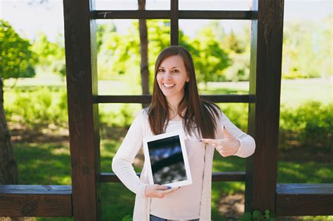 가벼운 캐주얼 옷을 입고 아름 다운 여자의 초상화입니다 미소 여성 태블릿 Pc 컴퓨터 봄 자연에 야외 거리에 도시 공원에서 공간을 복사할 빈 빈 화면 라이프 스타일