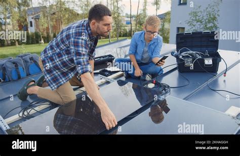 Father And Son Installing Solar Panels To A Metal Basis They Work With