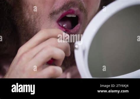 Extreme Close Up Of Male Hand Applying Red Lipstick On One Side Of Lower Lip Intersex Person