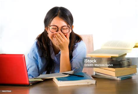 괴상 한 안경 작업 쾌활 한 노트북 컴퓨터 책상에 공부 하 고 미소도 서 더미에서에서 학생 소녀 흰색 배경에 고립 된 젊은 달