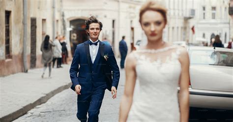 세련된 신부 산책과 도시 거리에서 그녀를 따라 달리는 신랑 행복한 럭셔리 웨딩 커플은 재미 있고 춤을 추고 있습니다 낭만적 인 순간 사진 Unsplash의 결혼식 이미지