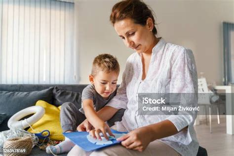 집에서 아들과 함께 노는 백인 여성 어머니와 함께 새로운 기술을 배우는 어린 소년 여자와 소년은 집에서 소파에 예술 공예를 만드는 개발 게임을 배운다 어린 시절 본딩 개념