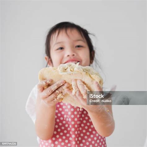 สาวเอเชียมีความสุขกับผ้ากันเปื้อนสีชมพูเตรียมแป้งสําหรับคุกกี้หรือแป้งพิซซ่าแนวคิดไลฟ ภาพสต็อก