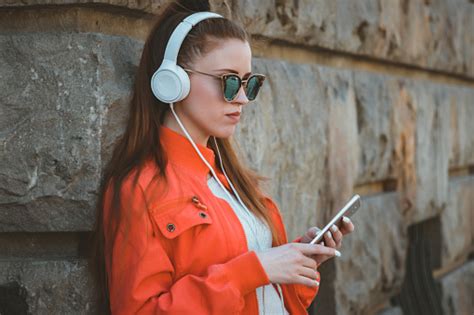 도시의 벽 근처 아름다운 여자는 그녀의 휴대 전화에 메시지를 입력 20 29세에 대한 스톡 사진 및 기타 이미지 20 29세 2명 Mp3 플레이어 Istock