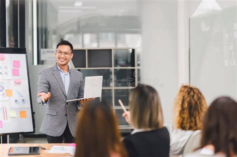 Confident Businessman Leading A Meeting Engaging With Colleagues While Presenting Data Charts