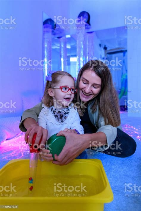 감각 자극 실에서 신체 장애가있는 어린이 Snoezelen 뇌성 마비와 함께 사는 어린이는 치료 세션 중에 치료사와 상호 작용합니다 2명에 대한 스톡 사진 및 기타 이미지