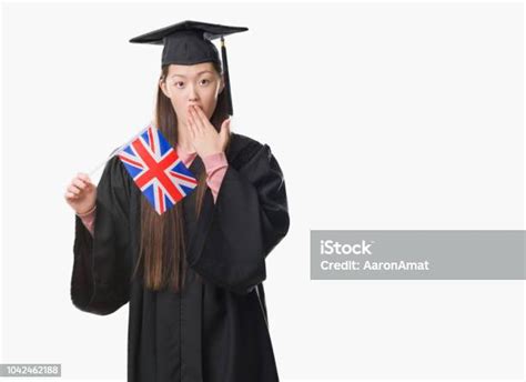 침묵 비밀 개념에에서 무서 워 하는 실수 두려움의 식을 위한 영국 국기 커버 입 수치와 충격을 손으로 잡고 대학원 유니폼을 입고 젊은 중국 여자 가리기에 대한 스톡 사진 및