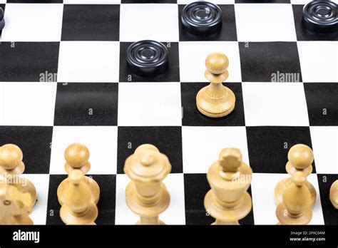 Playing By Different Rules On The Same Board Black Checkers And White Chess Figures On Black