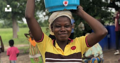 노란색과 검은색 줄무늬 폴로 셔츠를 입은 소년이 파란색 플라스틱 양동이를 들고 있다 사진 Unsplash의 무료 가나 이미지