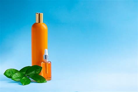 두 이랑 오렌지 병 및 녹색 파란색 배경에 그들 옆에 나뭇잎 태양 화면 효과 화장품 미용 건강 관리 및 피부 모발 보호 Uv 필터 복사 공간이 있는 가로 0명에 대한 스톡