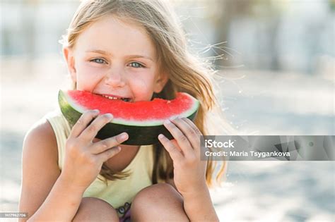 초상화 행복한 미소 아이 작은 사랑스러운 소녀는 해변에서 주스 수박 과일 조각을 먹습니다 여름철과 피크닉은 야외에서 배너 복사 공간 Fot 텍스트 배치 격리 자연 배경