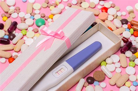 와 불 임의 치료 알 약 아이 임신에 도움이 됩니다 임신에서 정제 작동 하지 않습니다 피임 핑크 리본으로 선물 상자에 두 개의 스트립 긍정적인 임신 테스트 건강관리와 의술에
