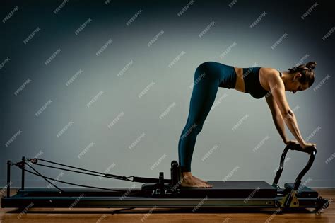 Premium Photo Young Girl Doing Pilates Exercises With A Reformer Bed