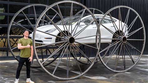 Tesla Model 3 встановили на колеса висотою 3 метри і спустили з пагорба ...