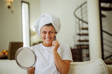 집에서 옥 롤러를 사용하면서 카메라를 위해 포즈를 취하는 아름다운 미소 짓는 여자 30 34세에 대한 스톡 사진 및 기타 이미지 30 34세 가꿔주기 가정 생활