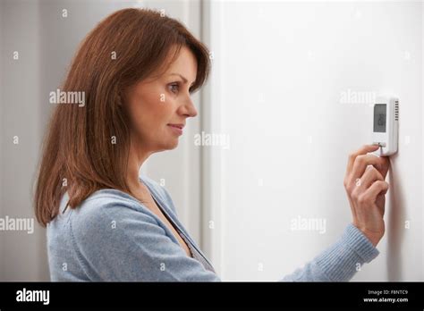 Woman Adjusting Digital Central Heating Thermostat Control Stock Photo Alamy