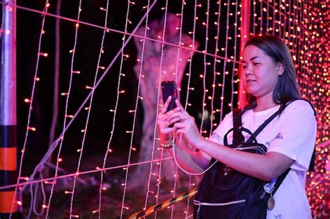 Premium Photo Woman Using Mobile Phone By Illuminated Lighting Equipment At Night