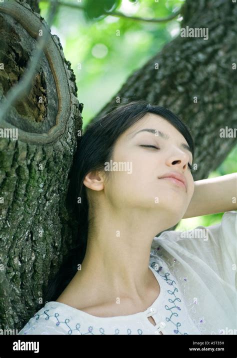 Woman Leaning Against Tree Stock Photo Alamy