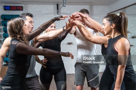 명랑 발랄 한 젊은이의 손을 함께 퍼 팅 하 고 체육관에서 그들의 일치를 보여주는 그룹 체육관에 대한 스톡 사진 및 기타 이미지