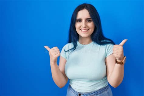 Young Modern Girl With Blue Hair Standing Over Blue Background Success
