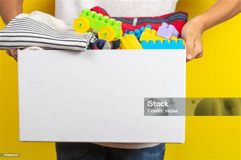 기부 개념입니다 책 옷 장난감 Ober 노란색 배경기부 상자를 들고 아이 손 노랑에 대한 스톡 사진 및 기타 이미지 노랑 자원봉사 Charitable